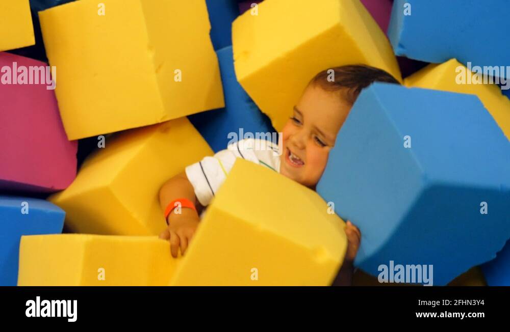 Boy playing in the soft foam pit in a jump house Stock Video Footage ...