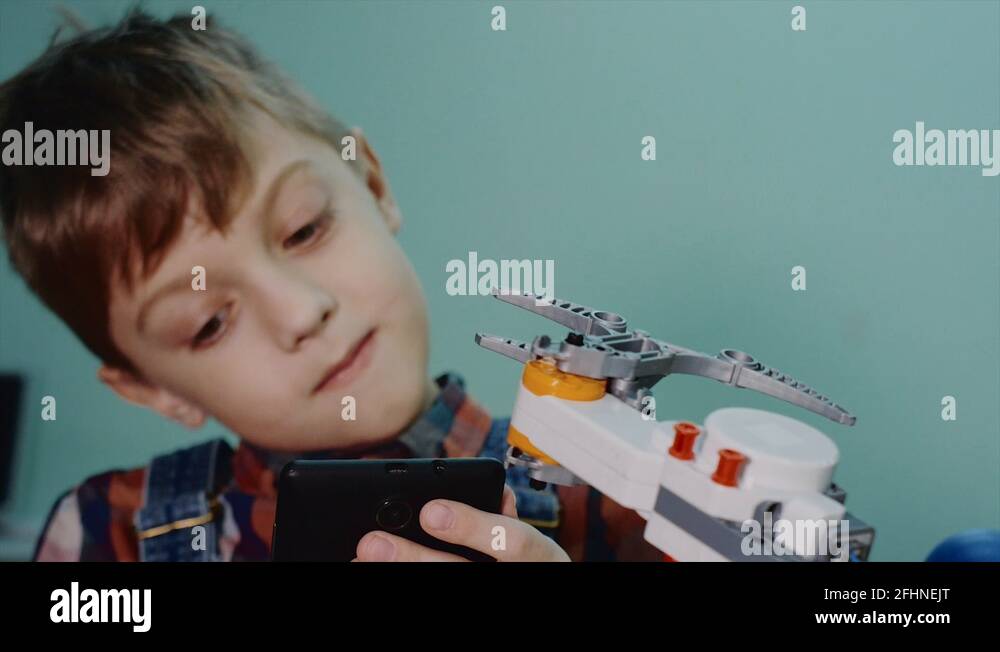 Little male kid is controlling robotic arm using application in ...