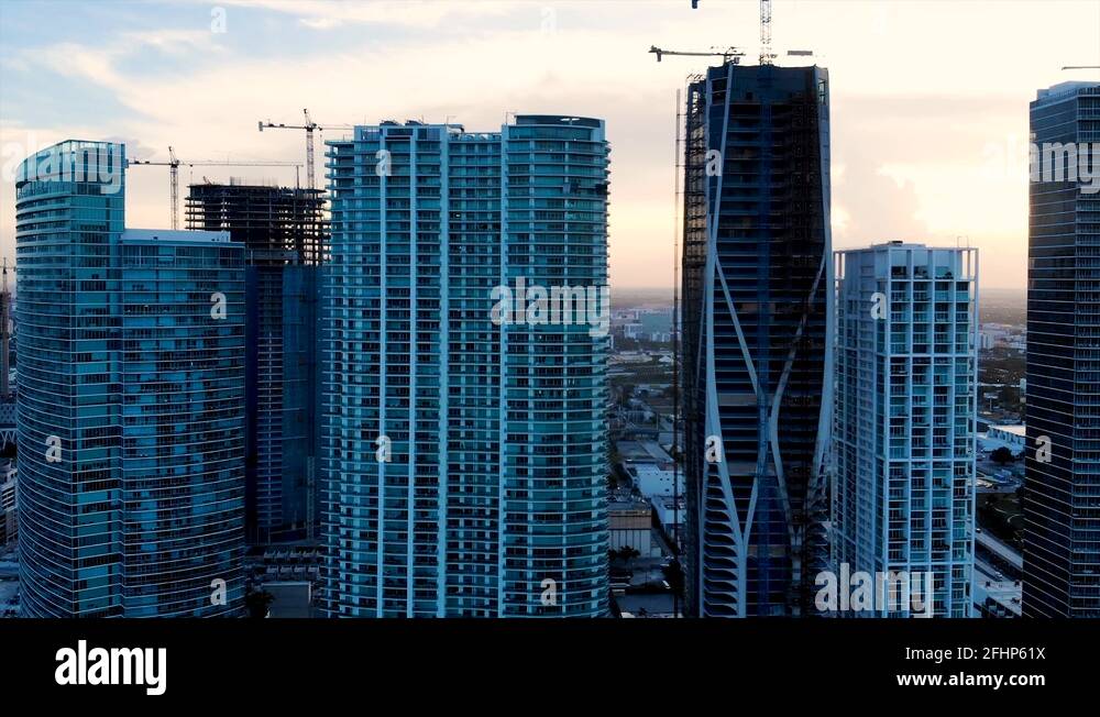 Drone ascending facing tall buildings in downtown. Construction towers ...