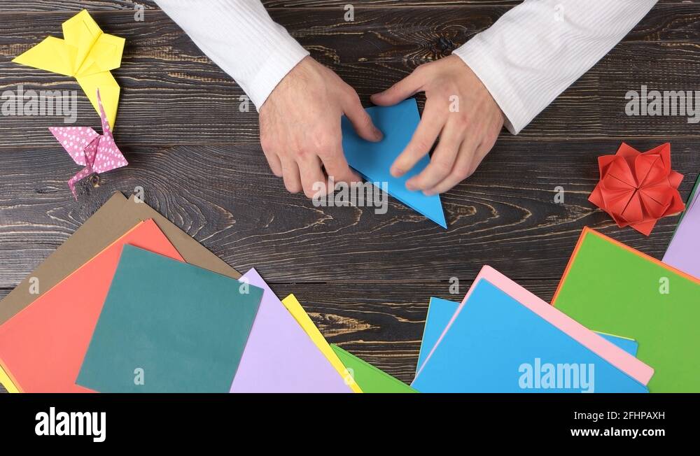 Male hands creating origami with blue paper, top view Stock Video ...
