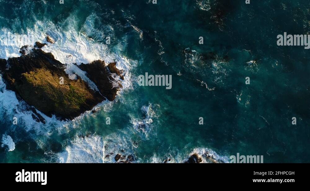 4K view directly above rocks, surf and cliff face on Lord Howe Island ...