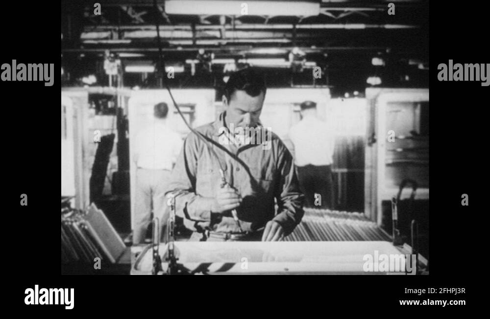 1950s: UNITED STATES: man works in factory. Man carries out task on ...