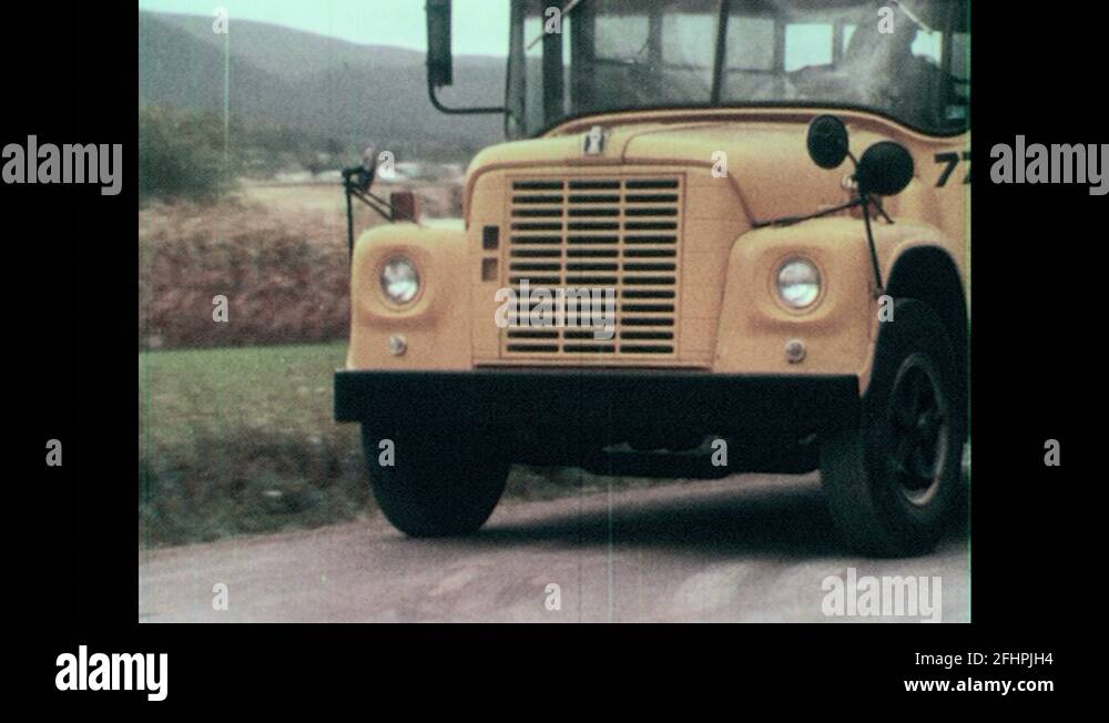 1980s: UNITED STATES: front view of yellow school bus. Bus stops on ...
