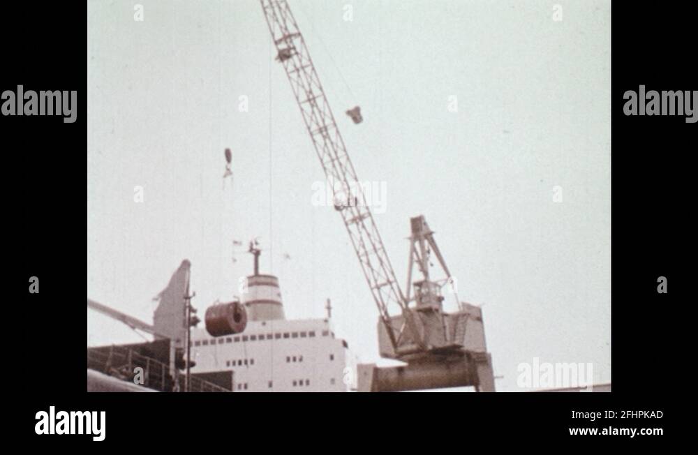 1970s: Docked boat. Large crane moves cargo Stock Video Footage - Alamy