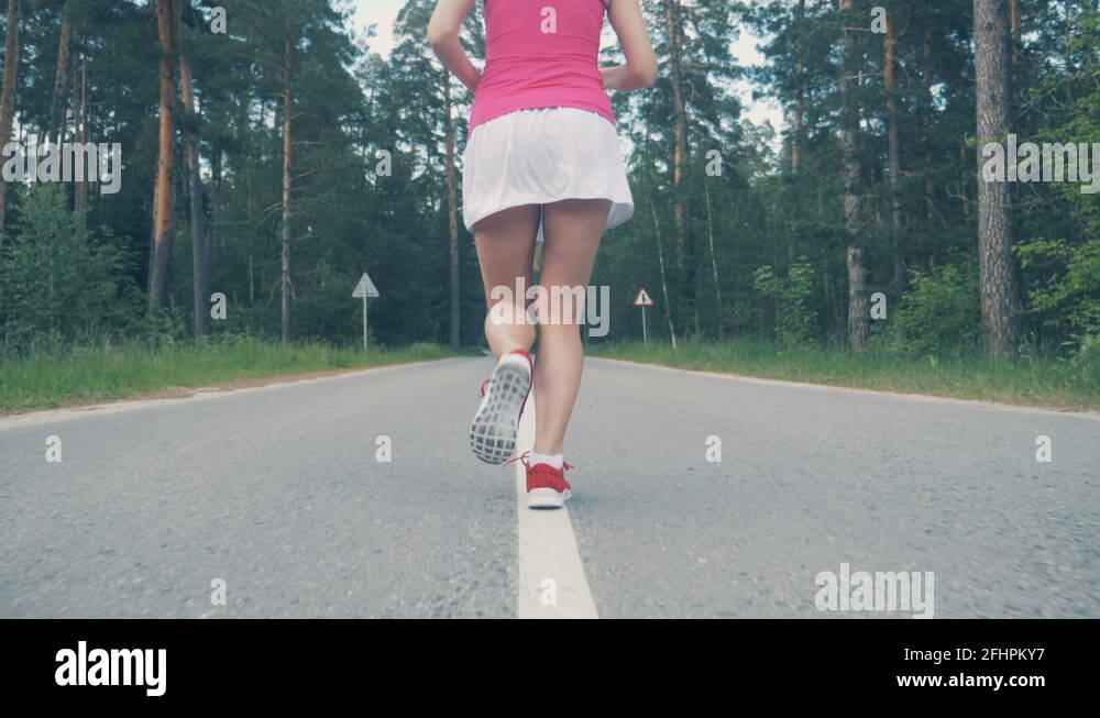 Back view of a female lower body while jogging in slow motion Stock ...