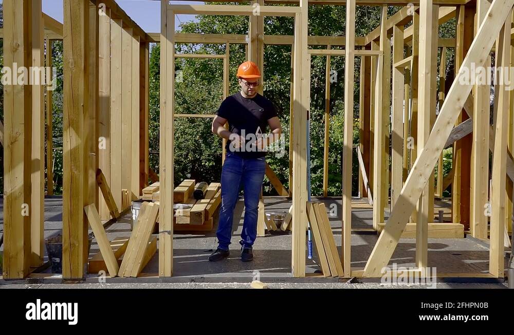 Construction worker measuring distance using tape measure building ...