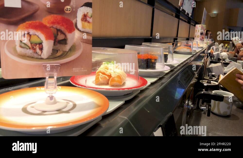 Portions of different types of sushiing on a conveyor belt inside a ...