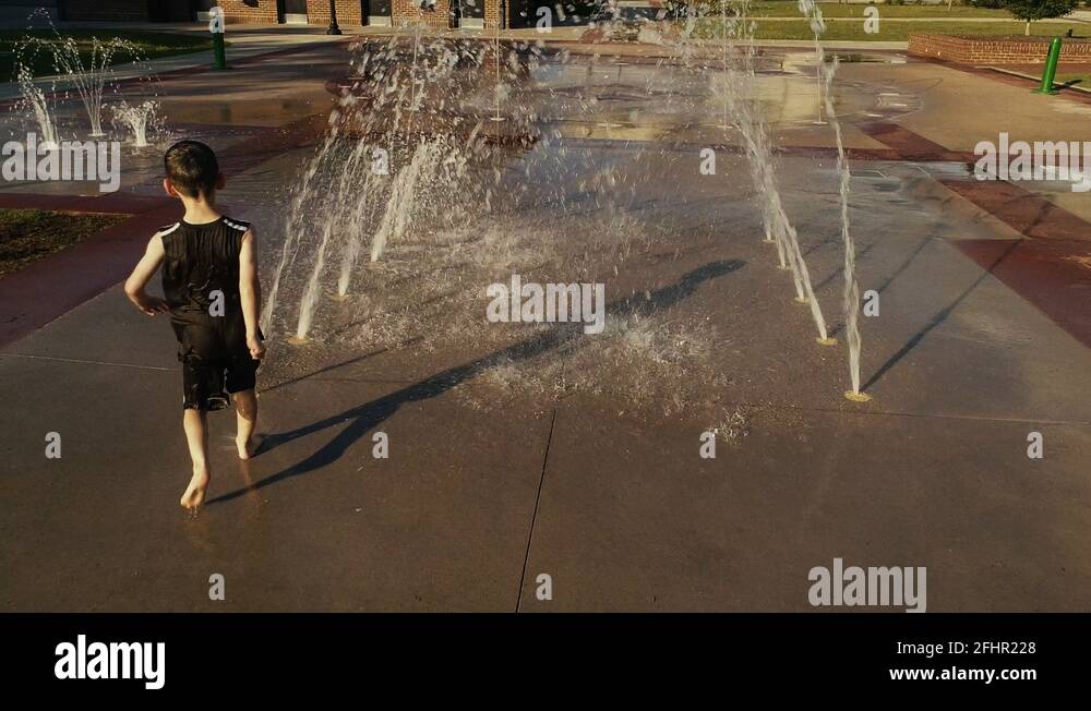 Young Boy Running Through Water Tunnel at a Splash Pad Stock Video ...