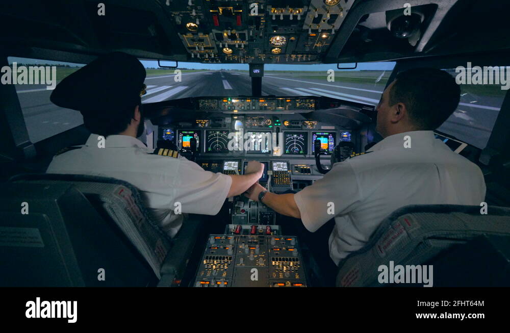 Male pilot is helping his trainee to control the plane simulator ...
