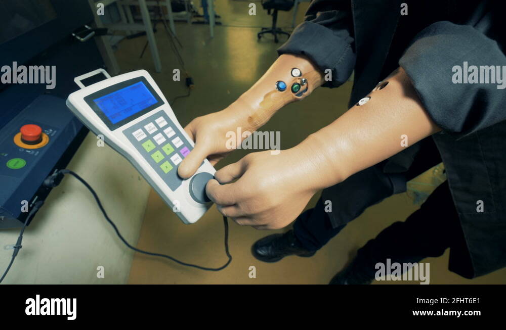 A person with artificial hands works with a console, turning a handle ...