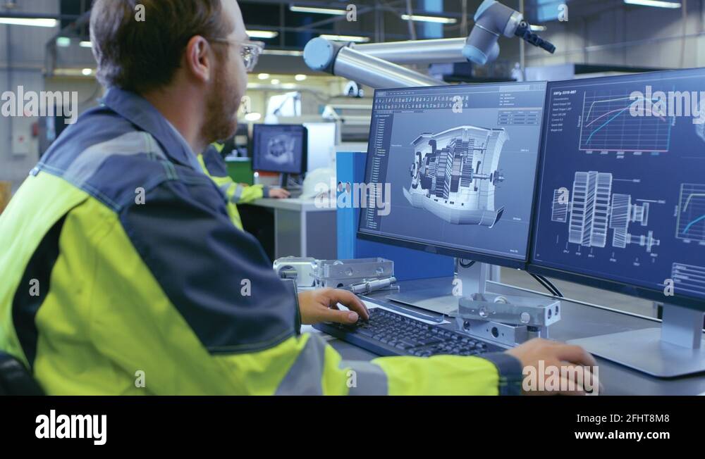 At the Factory: Mechanical Engineer Works on Computer, Designs in CAD ...