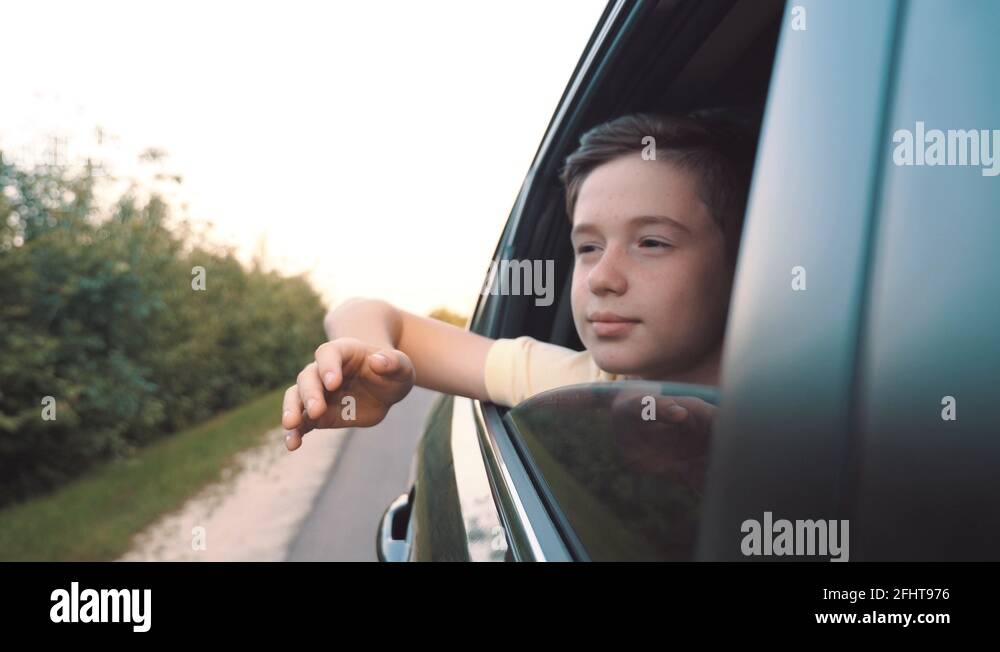 Teen boy looking out the car window and waving his hand Stock Video ...