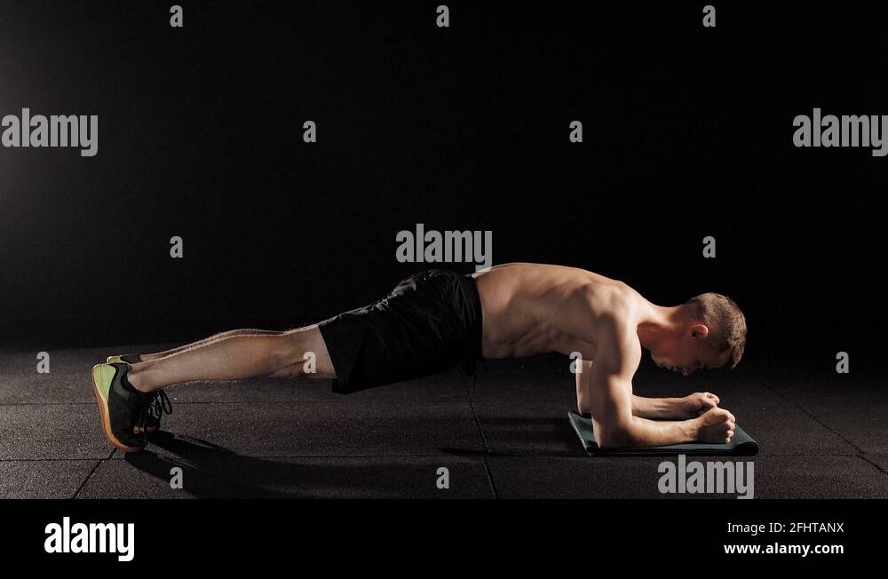 strong man is performing physical static exercise a plank, leaning by ...