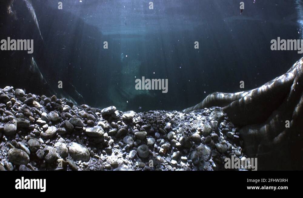 Refraction of sunlight underwater on smooth stones of river Verzasca ...