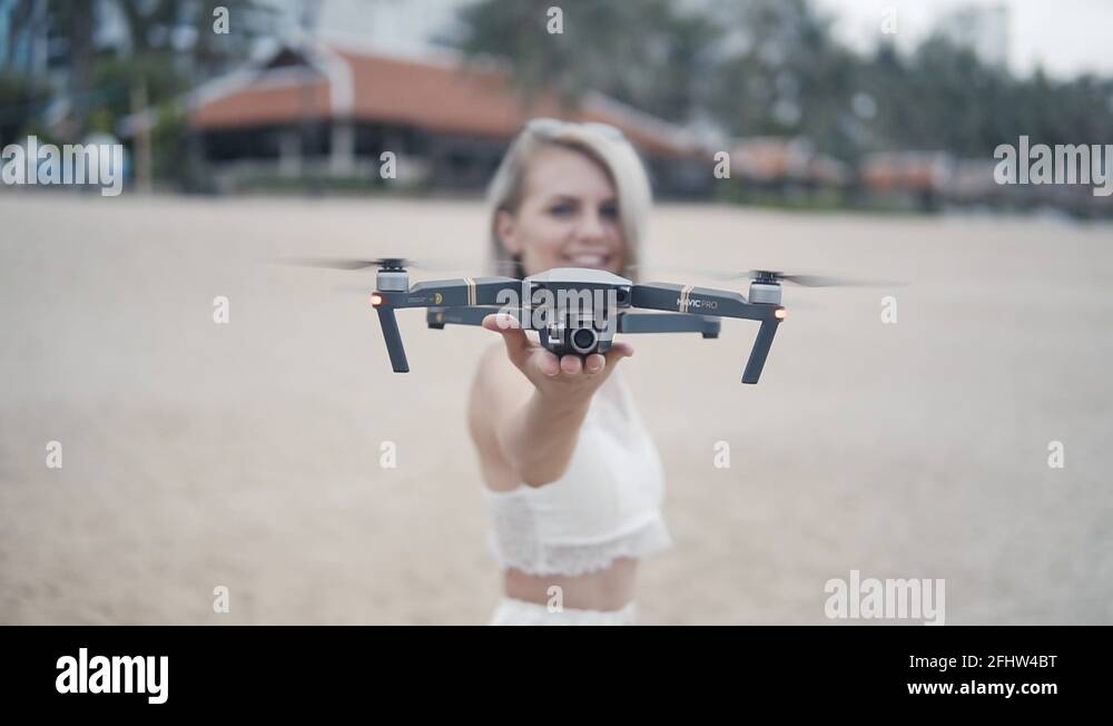 Drone is starting to taking off from woman's hands at seashore near the ...
