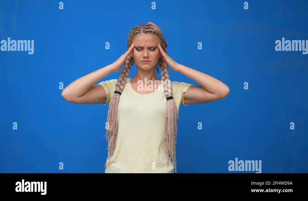 Fatigue stressful young female model keeps hands on head, closes eyes ...