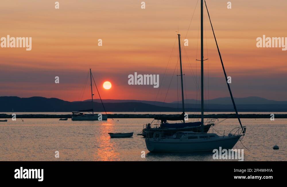People on the sailboat at sunset on Lake Champlain. Sailboating between ...