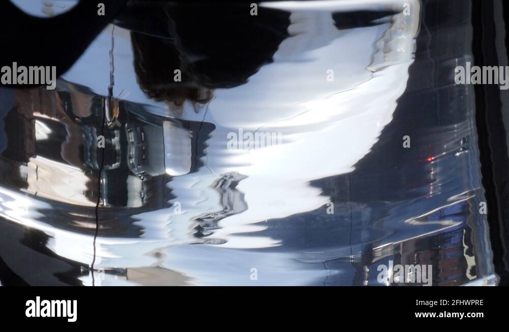 Abstract reflection in the metal mirror of a bus as various vehicles ...