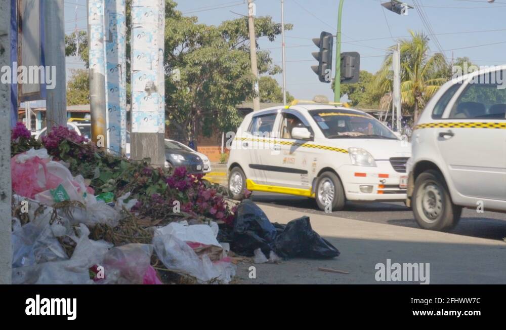 Taxi cars line up to pick up passengers next to piles of garbage on the ...