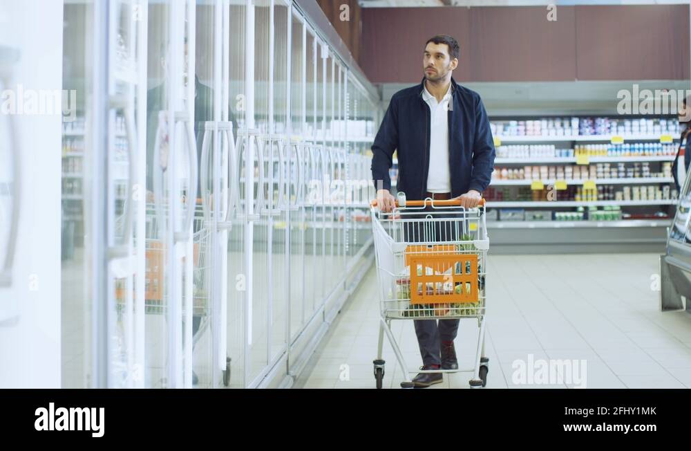 At the Supermarket: Handsome Man Opens Freezer Door and Puts Frozen ...
