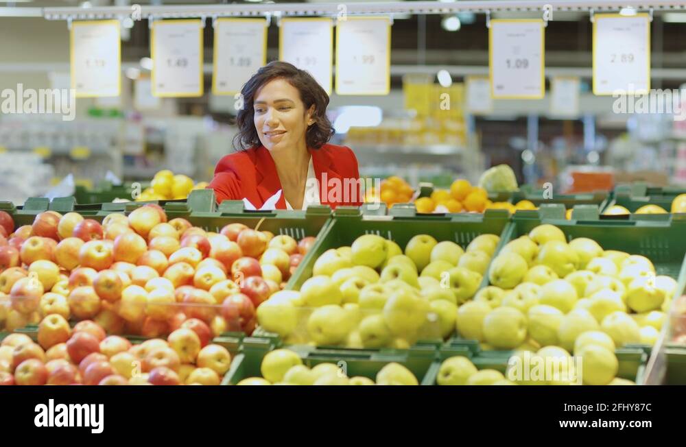 At the Supermarket: Beautiful Woman Chooses Organic Fruits in the Fresh ...
