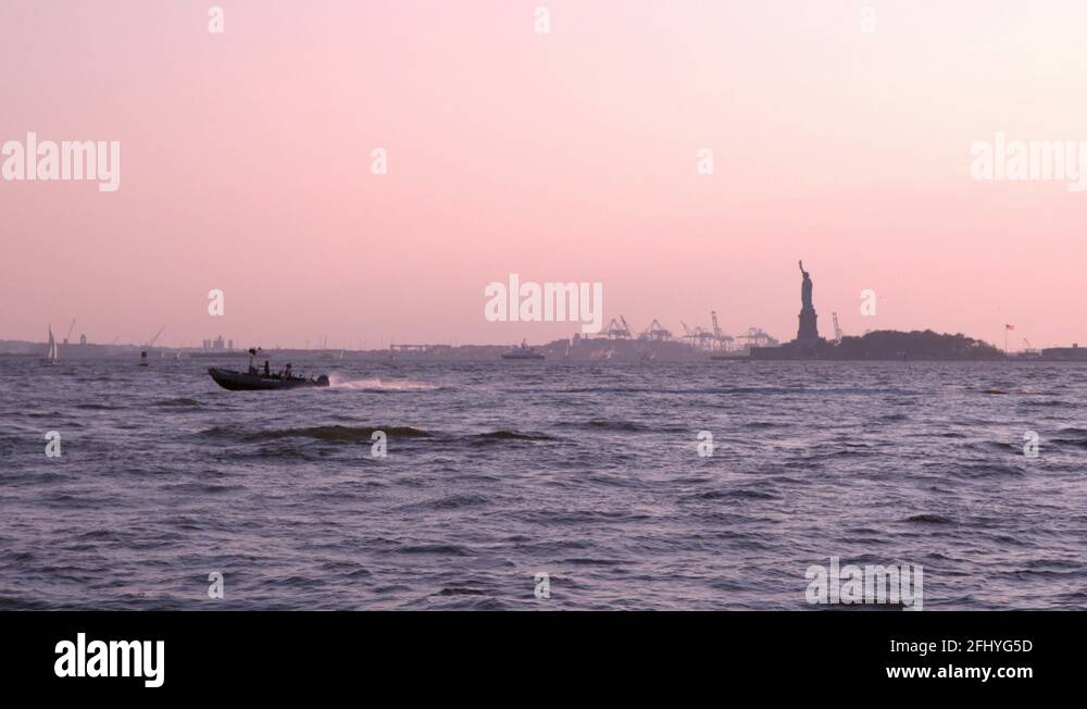 Speed boat goes by with Statue of Liberty in background slow motion ...