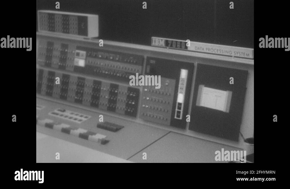 1960s: View of computer. Close up of computer panel. Paper feeding from ...