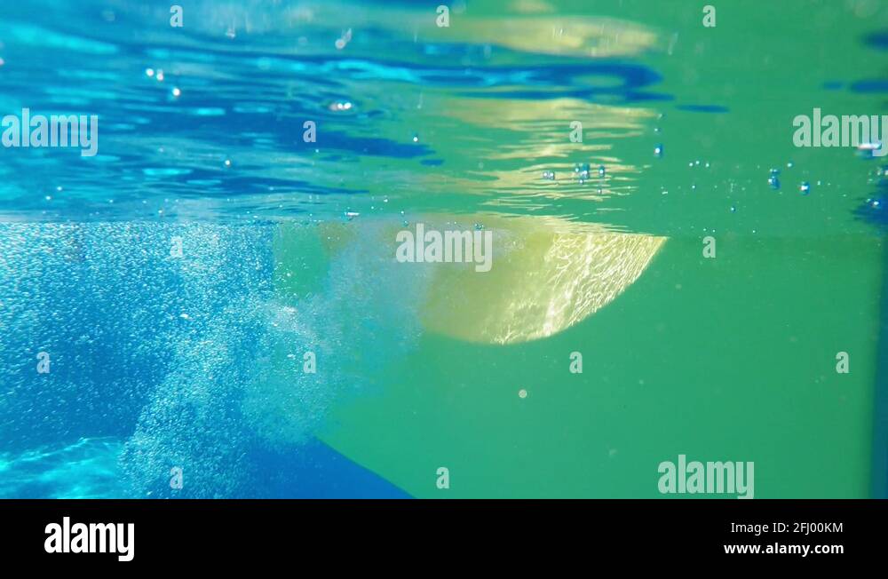 child falls in the pool from the water slide , underwater view, slow ...