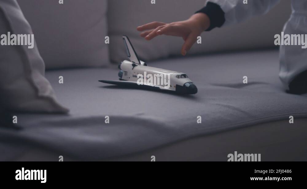 Cute little girl wearing astronaut suit playing with a toy space ...