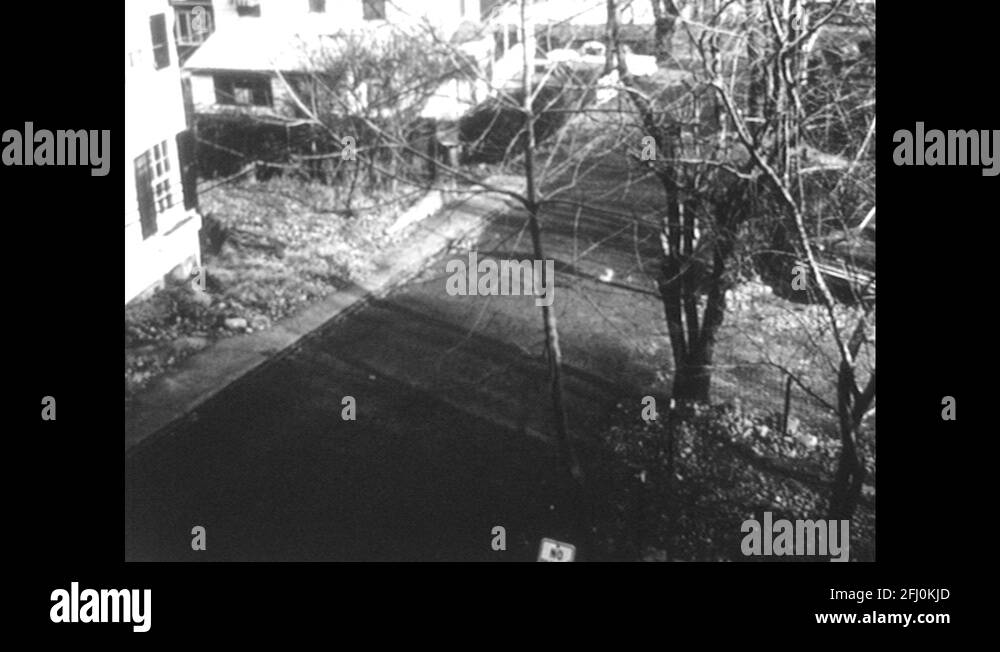 1960s: Street. Mailman delivers mail. Boy lays in bed. Feet walk on ...