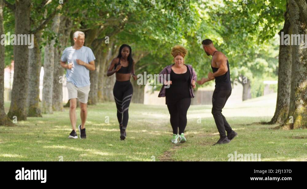 4K Fitness coach working out with diverse client group of mixed ages ...