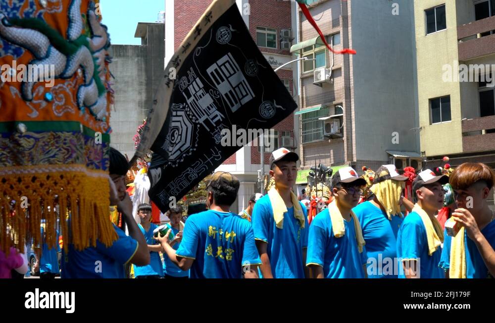 People gathering to walk in a parade with decorative costumes and flags ...