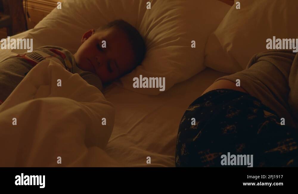 Two tired cute boys sleeping in the soft bed late at night Stock Video ...