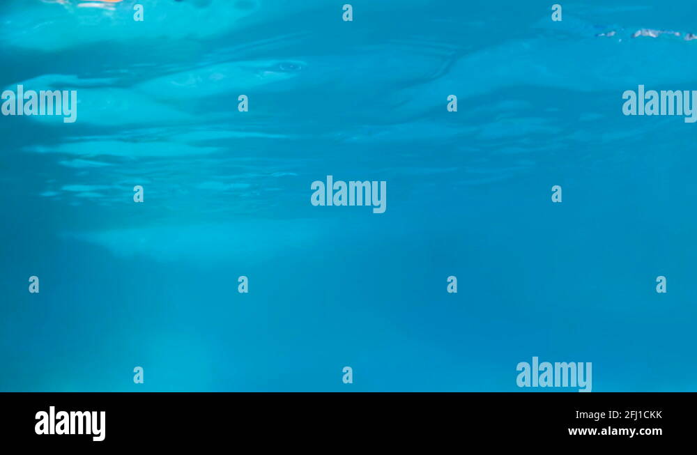 Slow motion footage of people swimming and jumping in swimming pool at ...