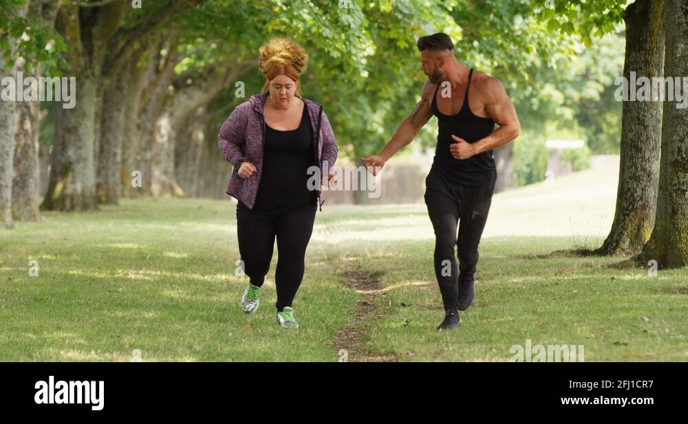4K Fitness coach working out with obese woman, giving motivation ...
