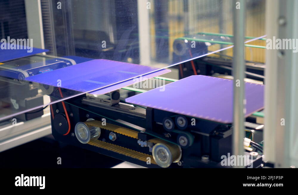 Solar module cells are moving along the conveyor belt one by one ...
