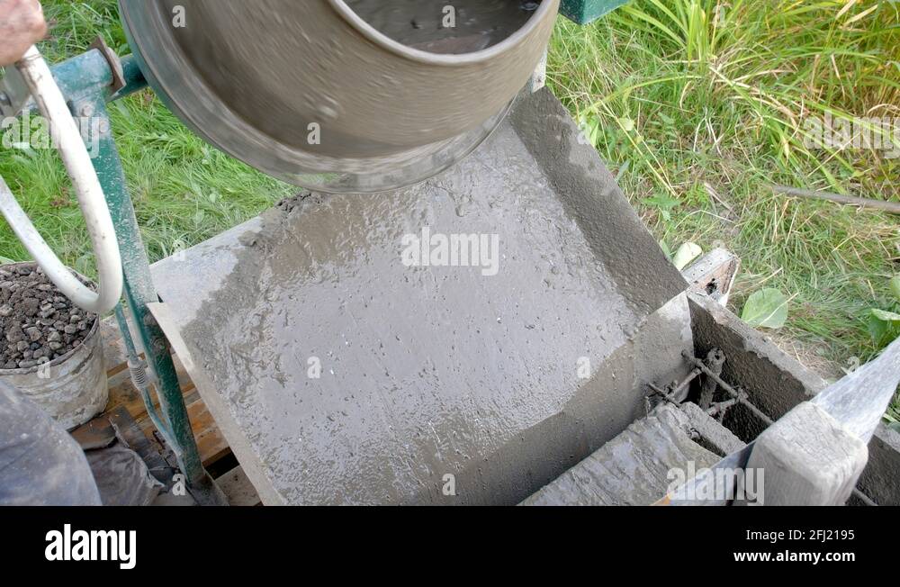 Concrete pouring. Construction worker mixing mortar. Pouring concrete ...
