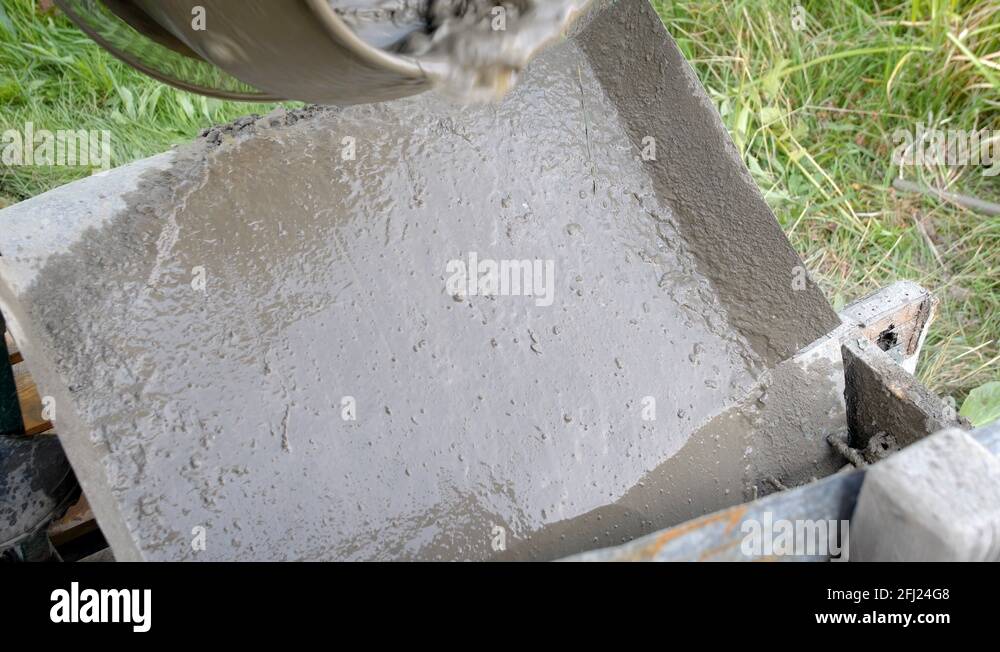 Concrete pouring. Construction worker mixing mortar. Pouring concrete ...