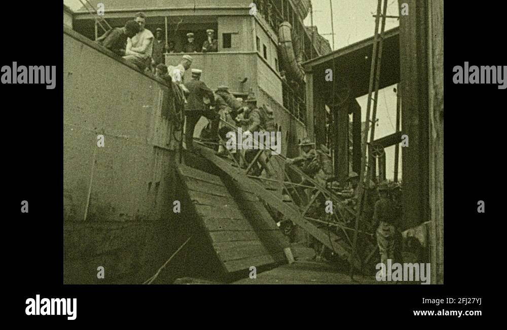 1910s: Soldiers walk up steps, board ship. Crowd of soldiers on ship ...