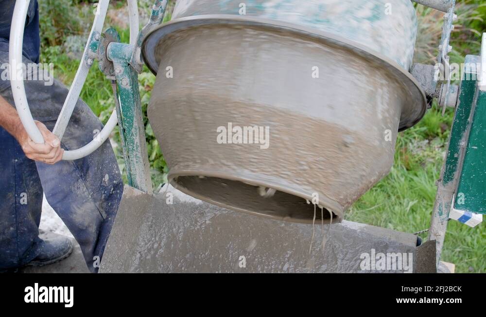 Concrete pouring. Construction worker mixing mortar. Pouring concrete ...