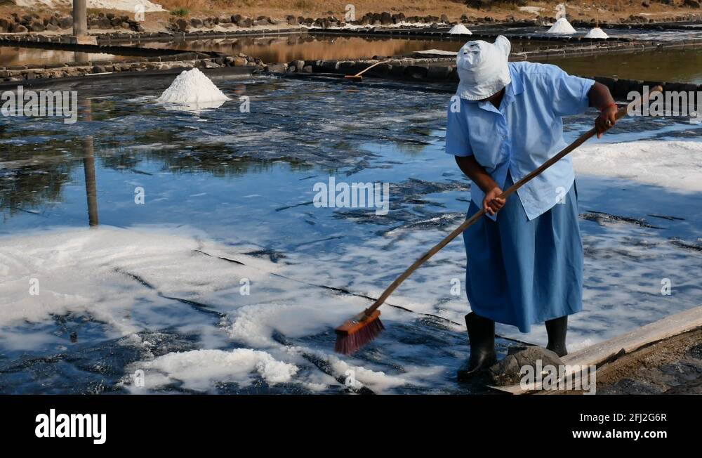 4K Woman salt farming from sea water evaporation ponds Stock Video ...