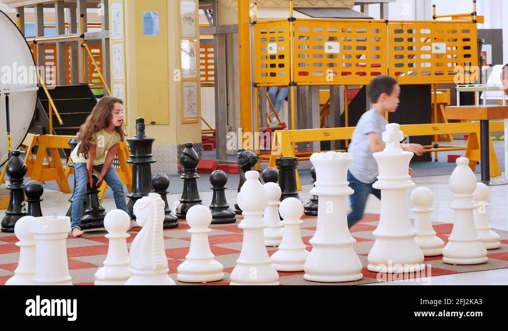 Three kids playing giant chess at a science activity centre Stock Video ...