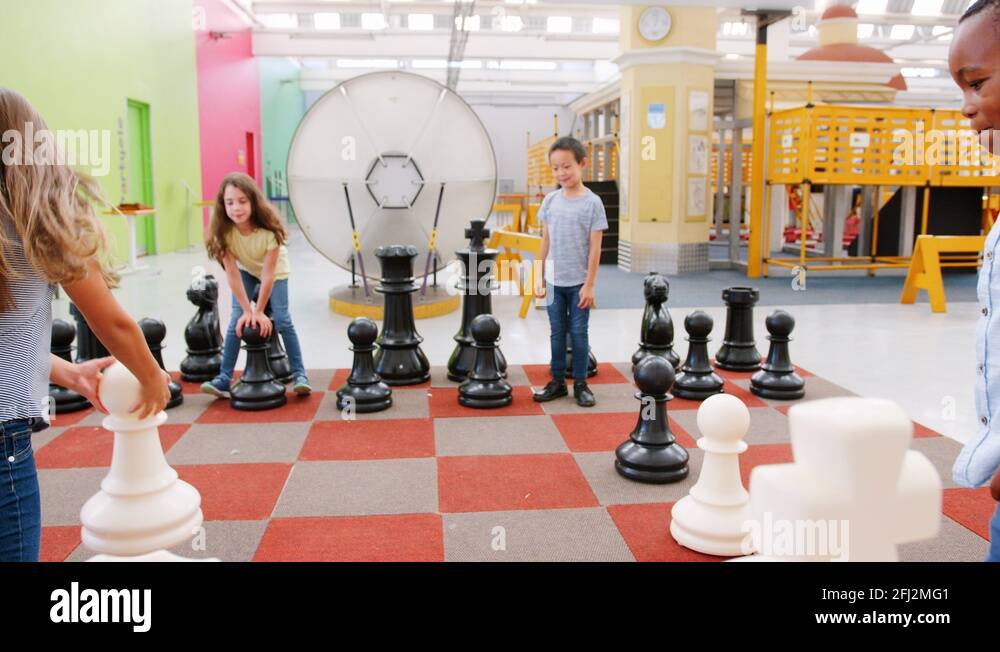 Four kids playing giant chess at a science activity centre Stock Video ...