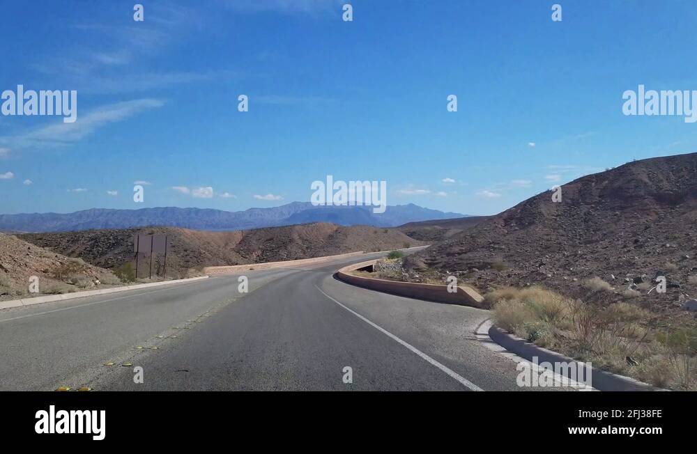 Driving in a curved highway in the desert with a panoramic view of the ...