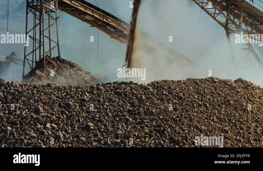 Industrial sand mining. Falling gravels from belt behind a pile of ...