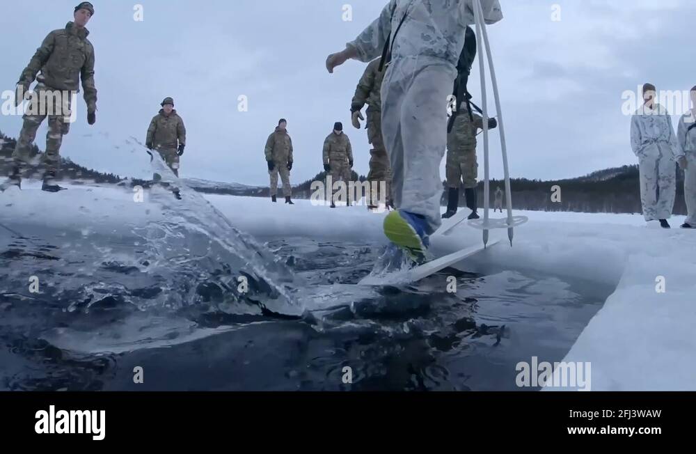 Troops conduct ice-breaking drills jumping fully into freezing water ...