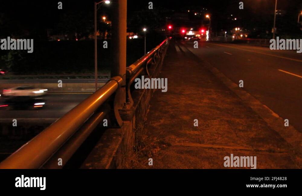 Walking over freeway overpass at night with traffic on freeway Stock ...