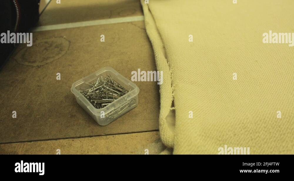 Fabric is pinning by the edges, a black man carefully designs the ...