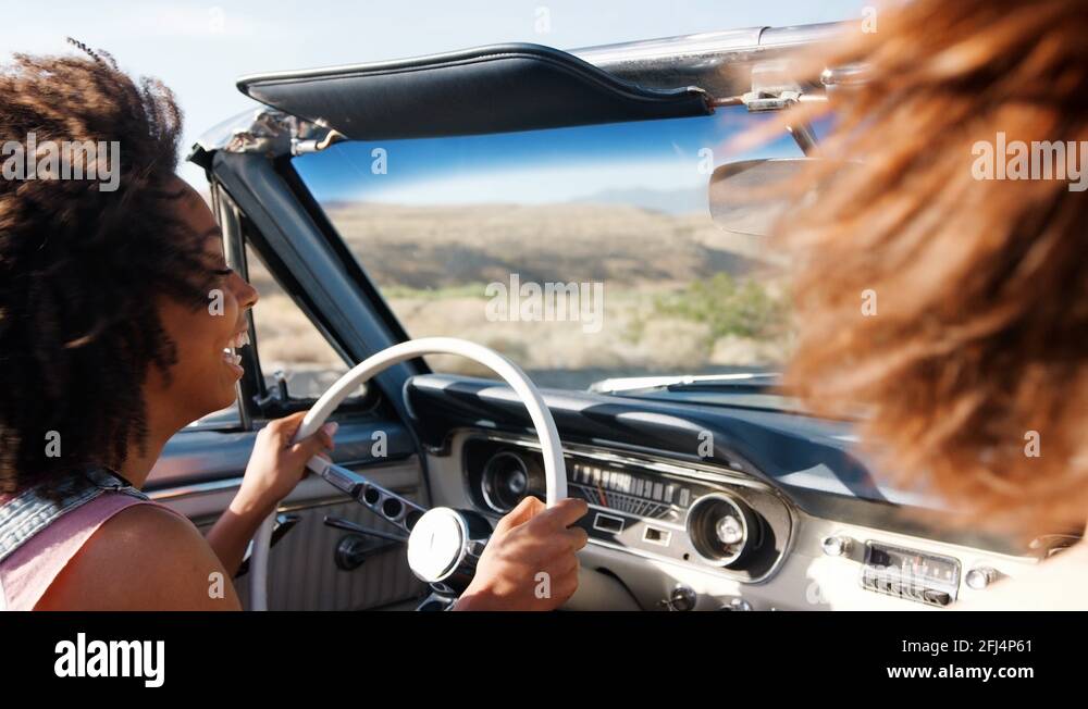 Two female friends driving in an open top classic car Stock Video ...