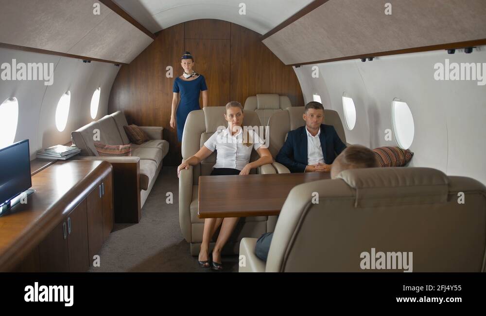 Pretty stewardess offers help and service for luxury private jet ...